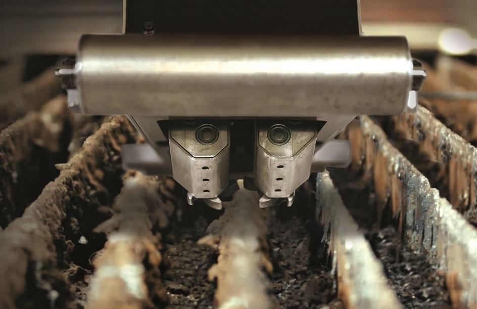 Machine cleans slag buildup from plasma cutting table slats